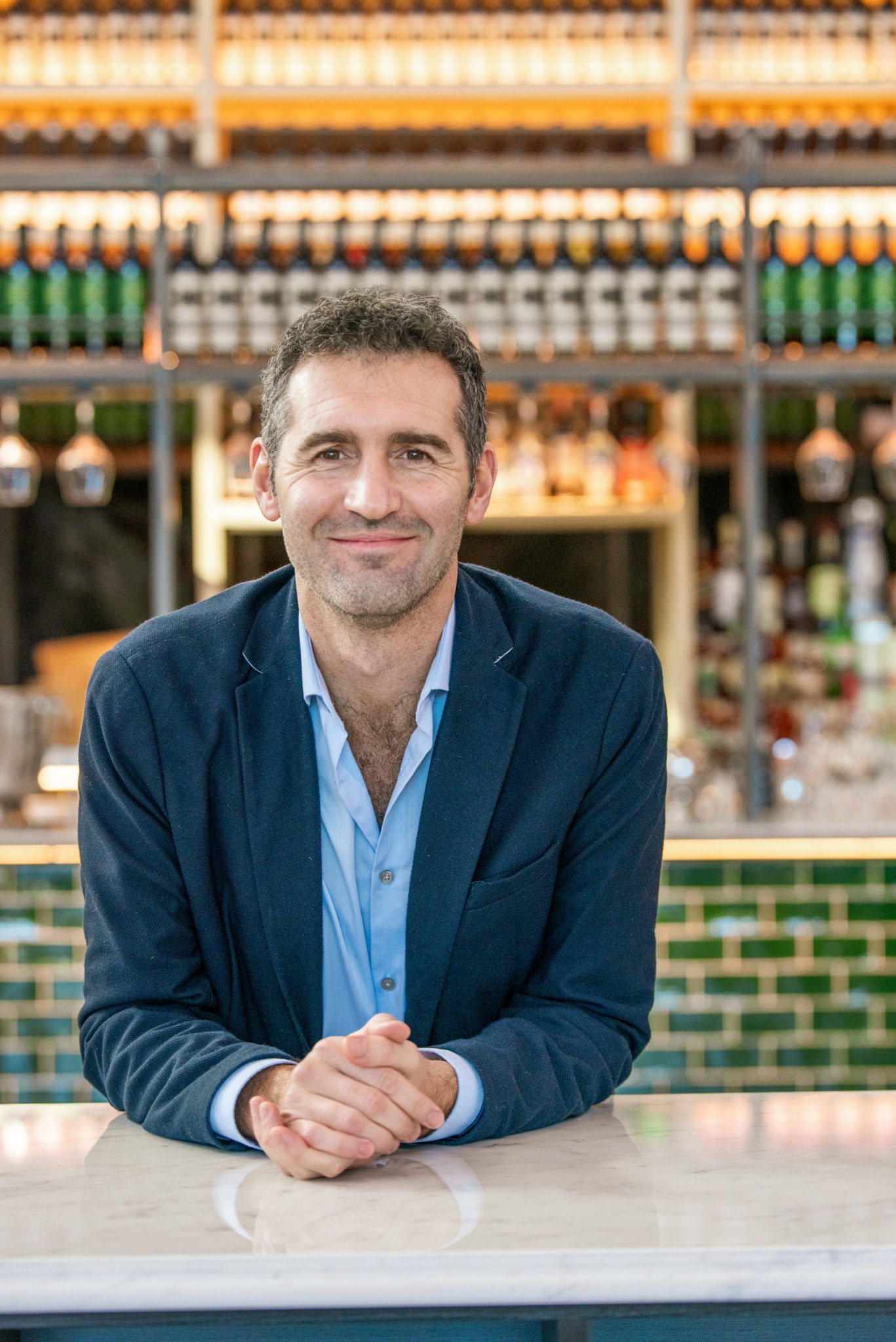 Dino Borri, Italian food expert. Headshot of man in suit, bottles ...